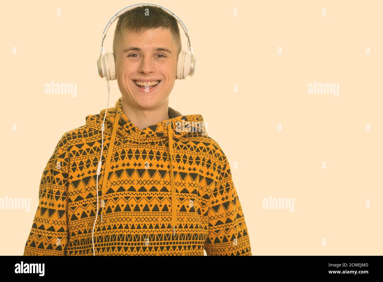 Young happy Caucasian man smiling while listening to music Stock Photo ...