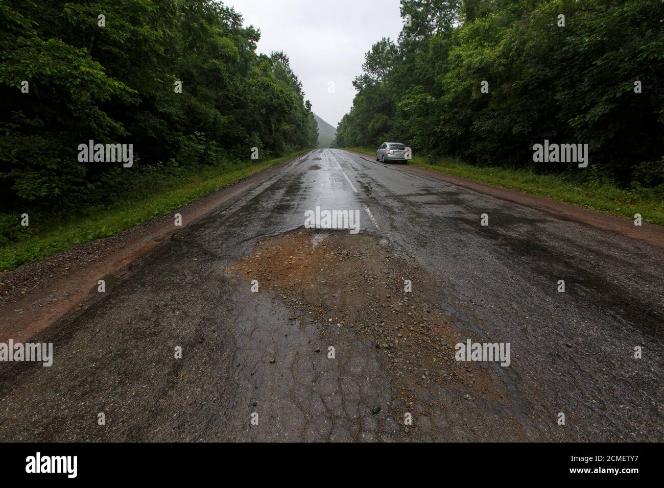 Very bad road in Russia. The asphalt road is all in holes in the middle ...