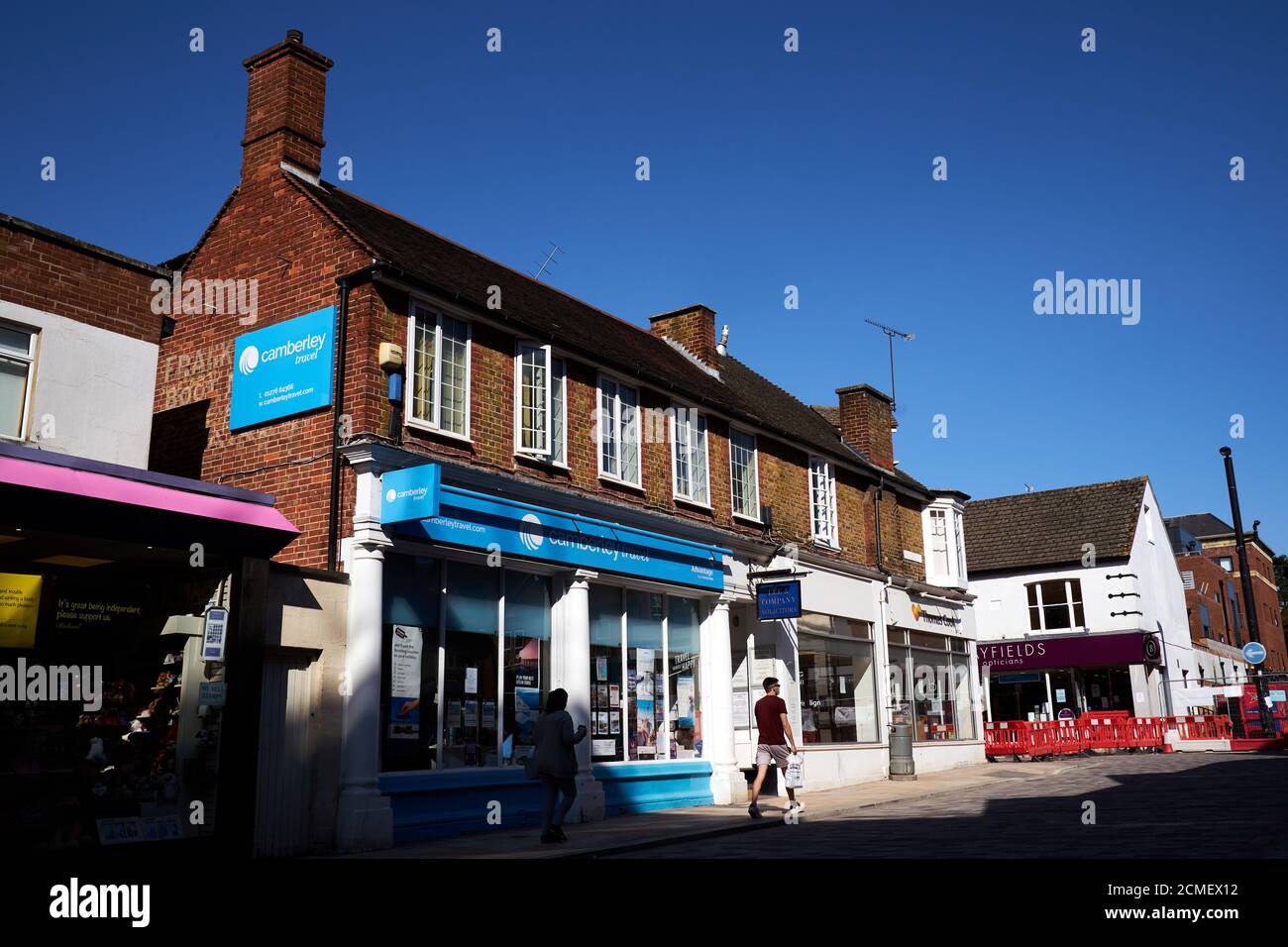 A member of the public walks past Camberley Travel which is open and a ...
