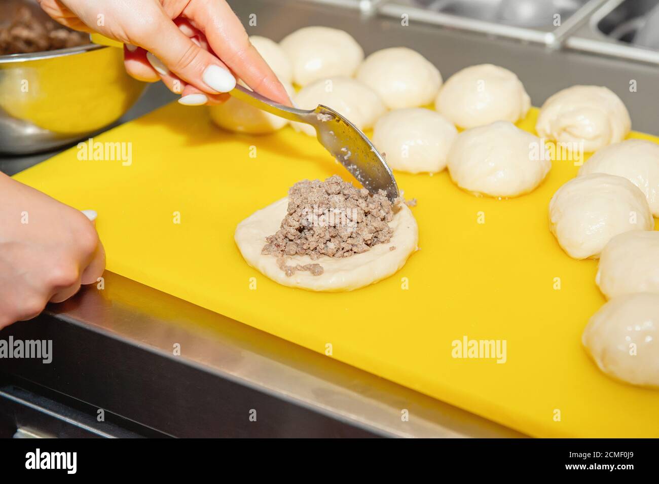 cook puts the filling in meat pies. Chef's hands make meat pies, close ...