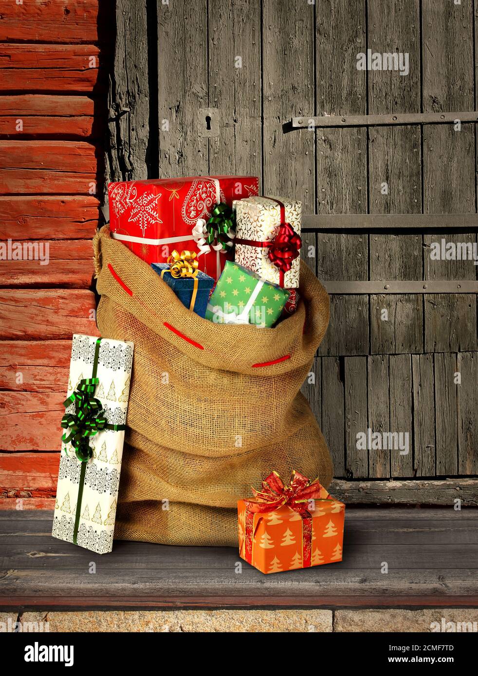 Santas present sack with gift boxes on rough wooden log cabin entrance ...