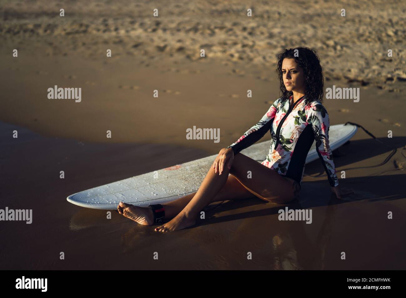 Beautiful young surfer woman with a surfboard having fun on the beach ...