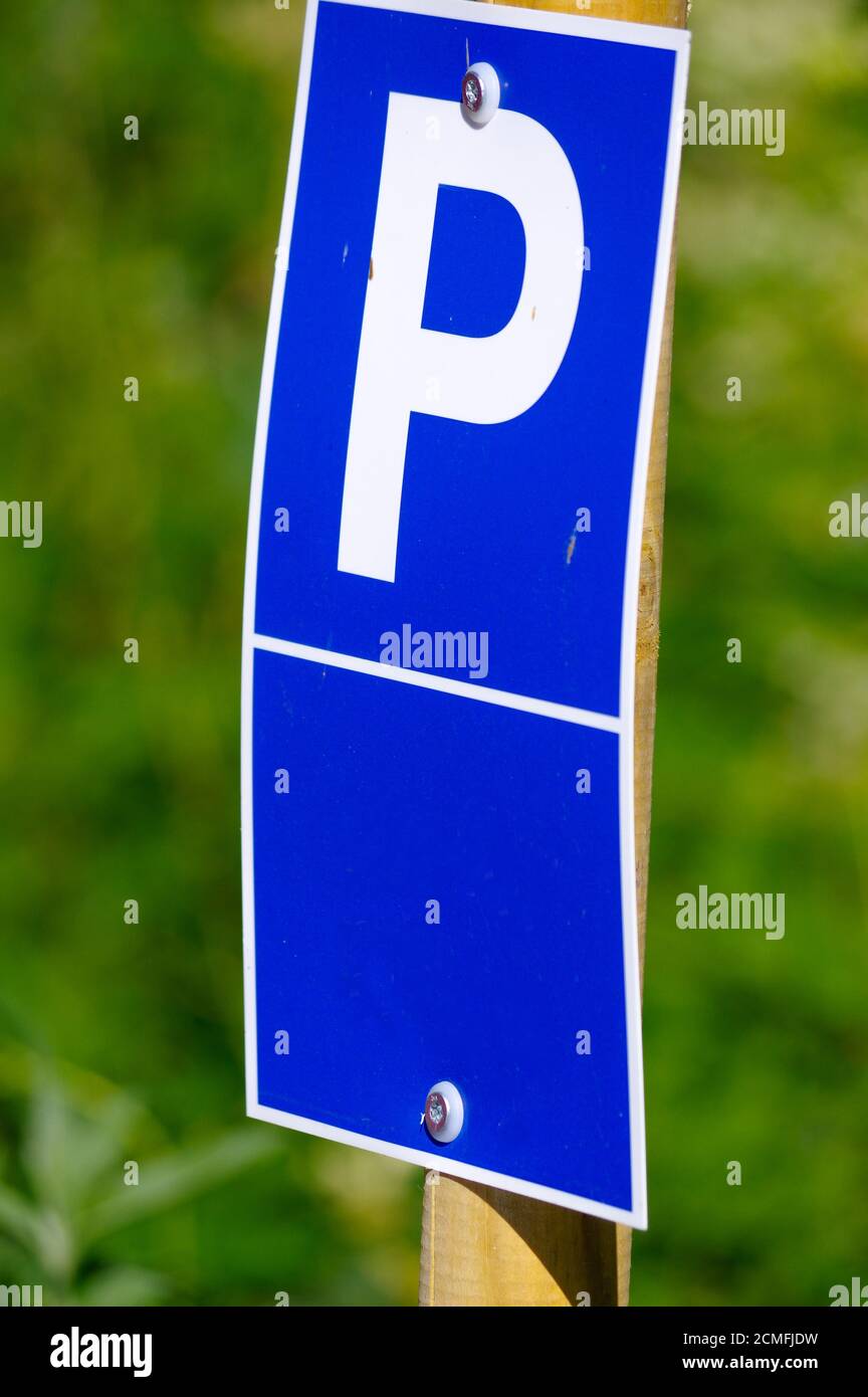 blue parking sign with a big P on it and green background Stock Photo ...