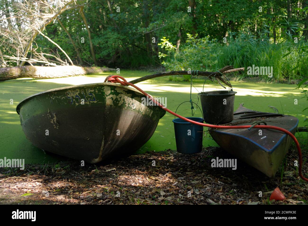 Old canoe and a wooden boat ashore the pond with bucket on it Stock ...