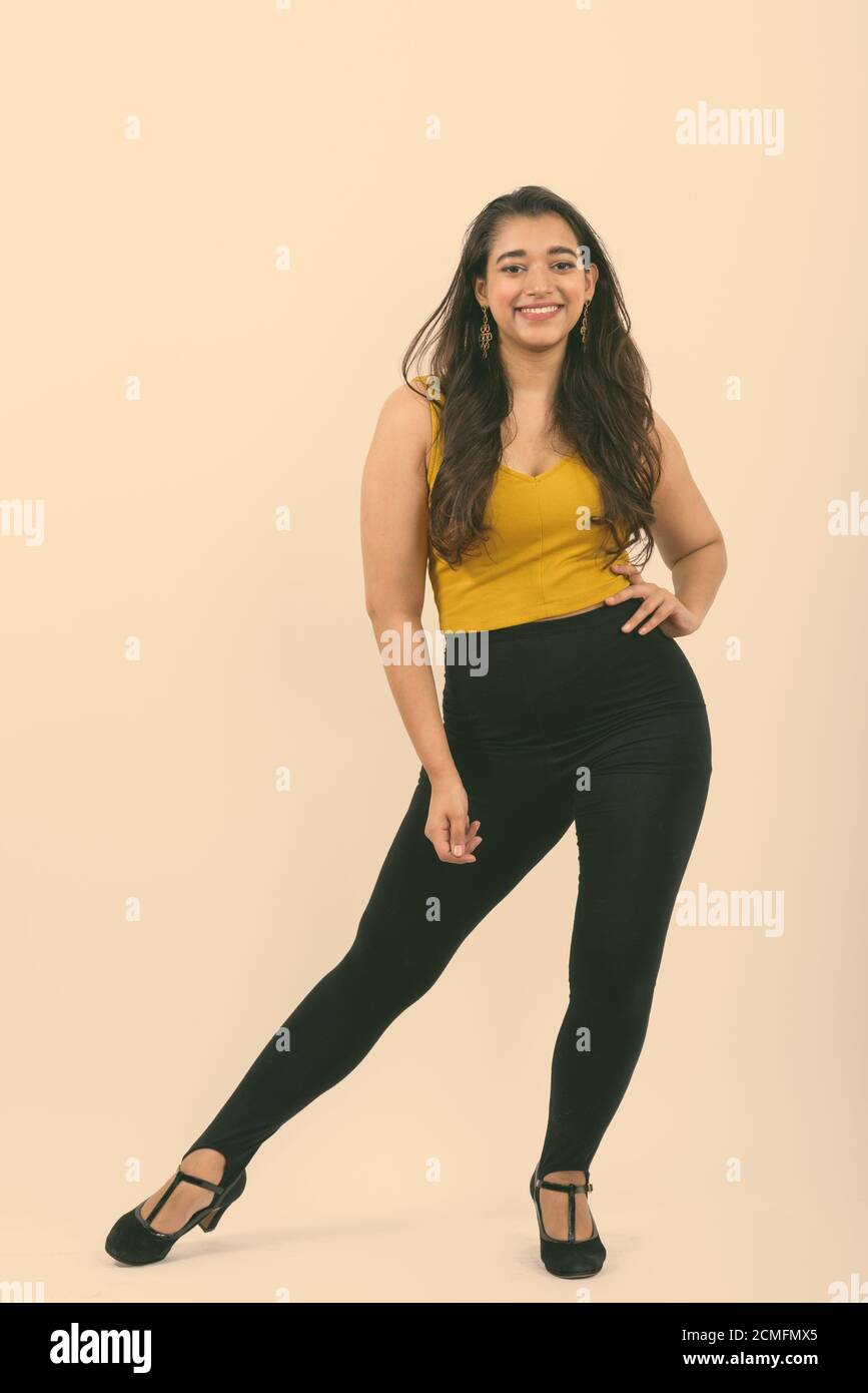 Full body shot of young happy Indian woman smiling while posing and ...