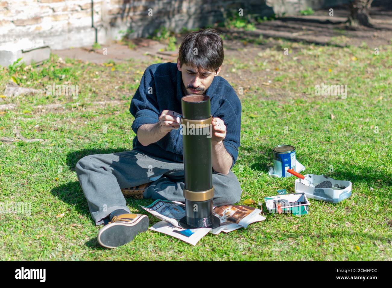Craftsman restoring a black vase in a park Stock Photo - Alamy