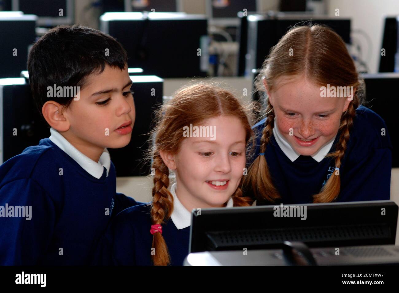 Primary school pupils using computers hi-res stock photography and ...
