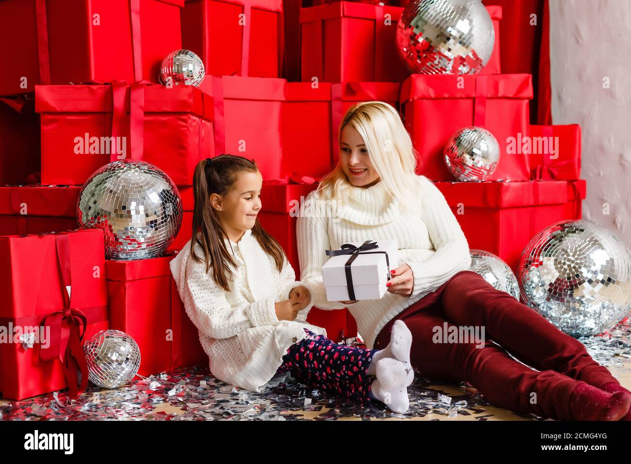 Little beautiful pretty girl giving a gift to her happy mother ...