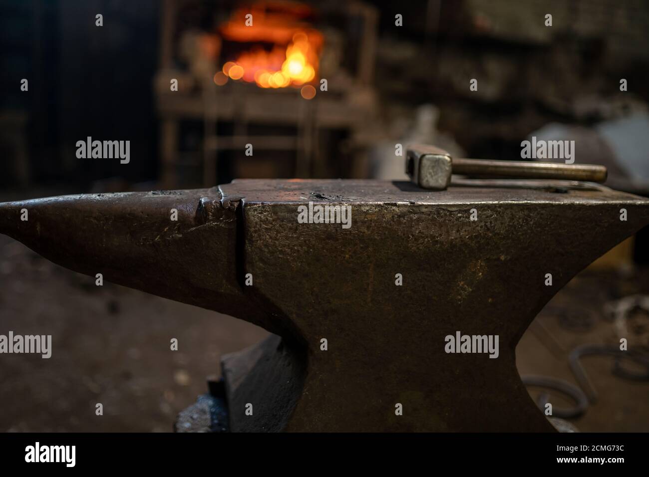 A blacksmith's hammer lies on an anvil against the background of a ...