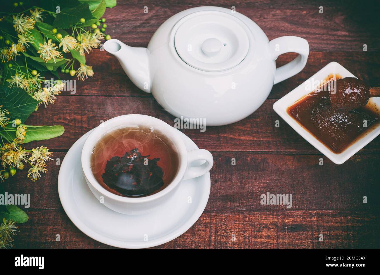White cup of hot black tea, teapot and honey of linden tree Stock Photo ...