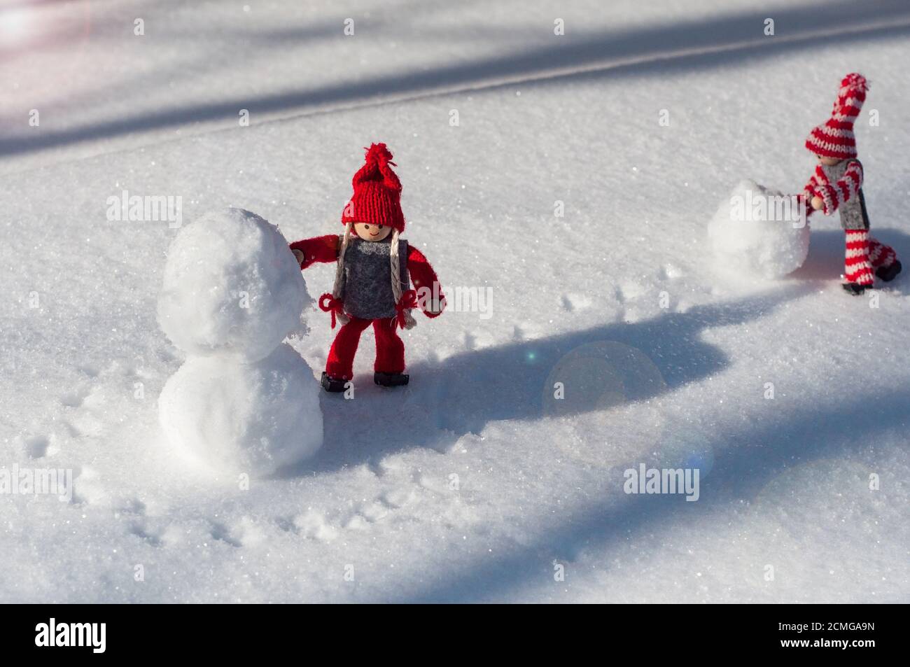 Two toy little man rolled a snowball Stock Photo - Alamy