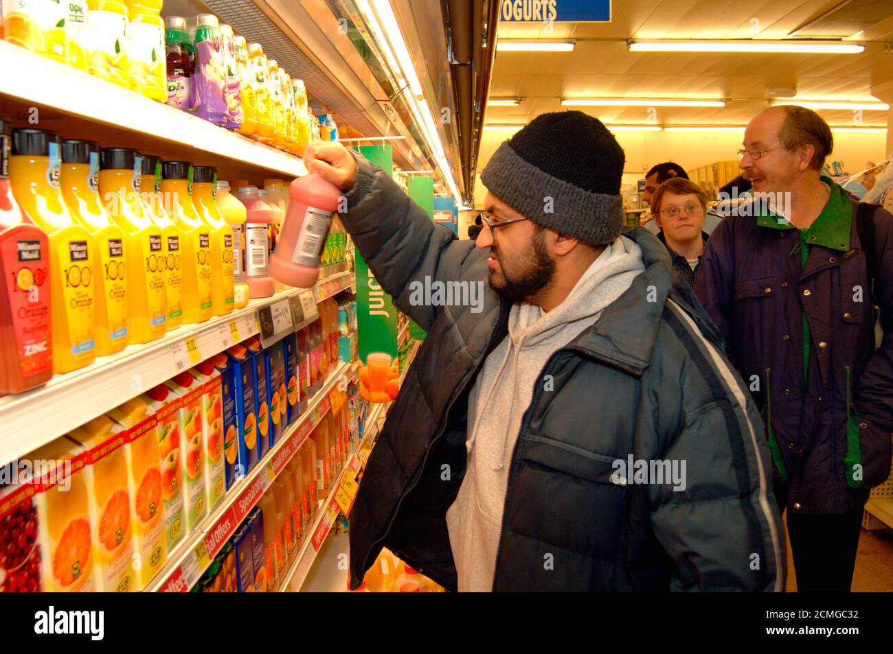Group of men with learning disabilities shopping with carer; Bradford ...