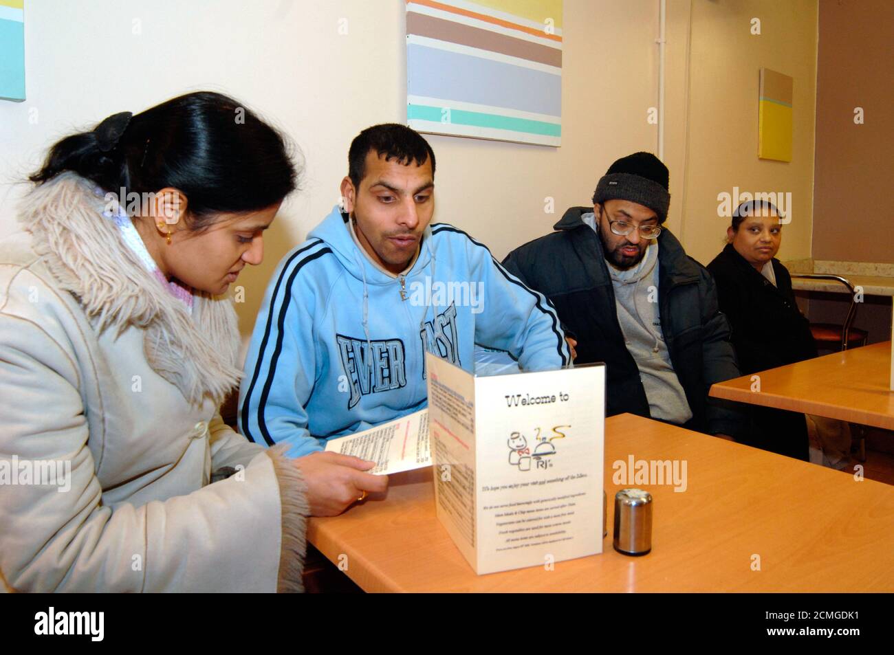 Group of men with learning disabilities in cafe with carer; Bradford ...