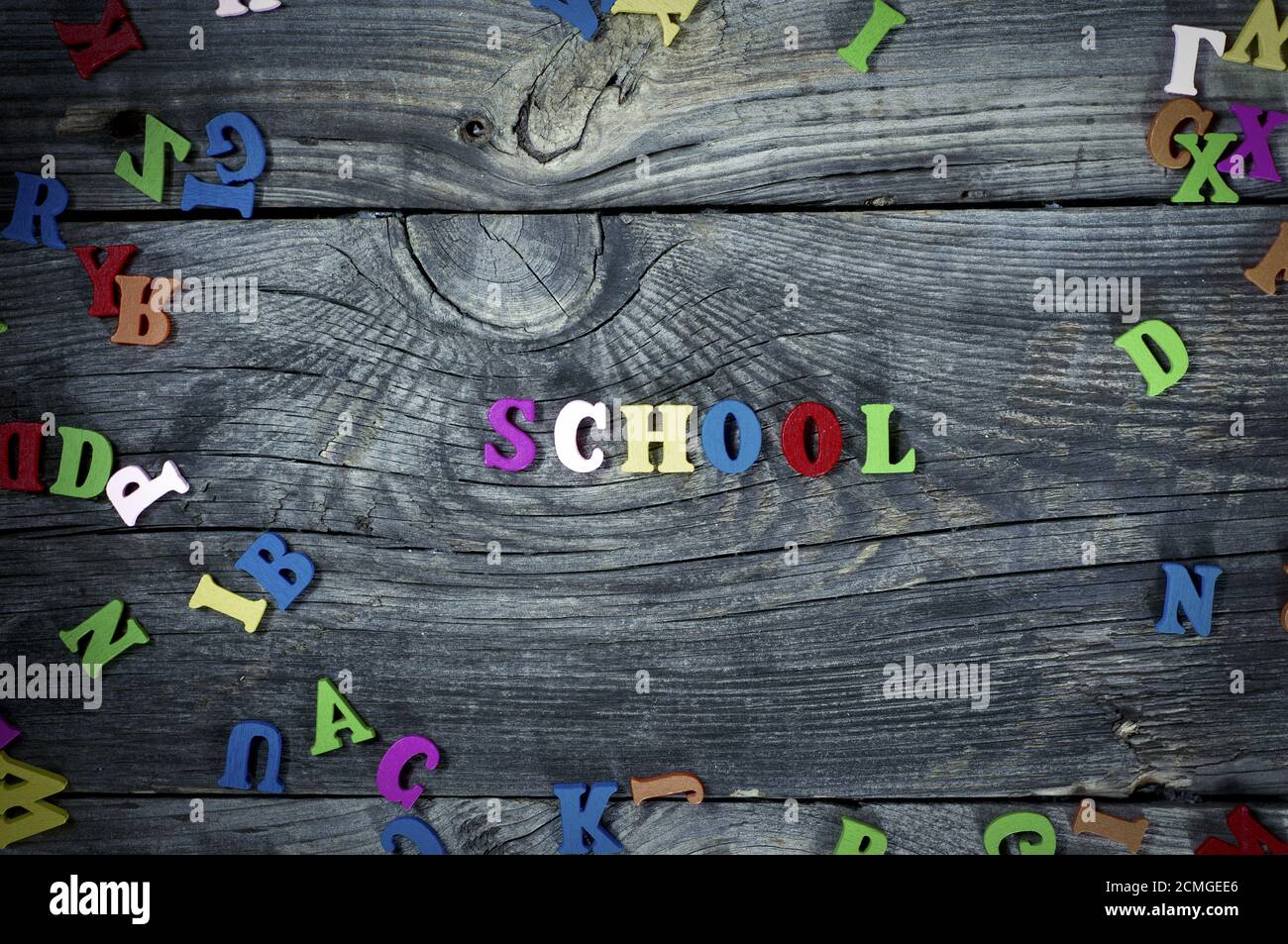 Grey wooden background with colorful small letters Stock Photo - Alamy