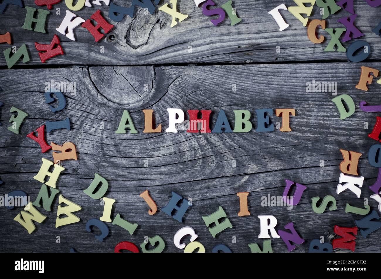 Grey wooden background with colorful small letters Stock Photo - Alamy