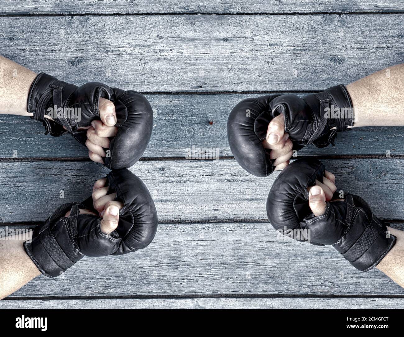 Two pairs of human hands in black leather boxing gloves facing each ...