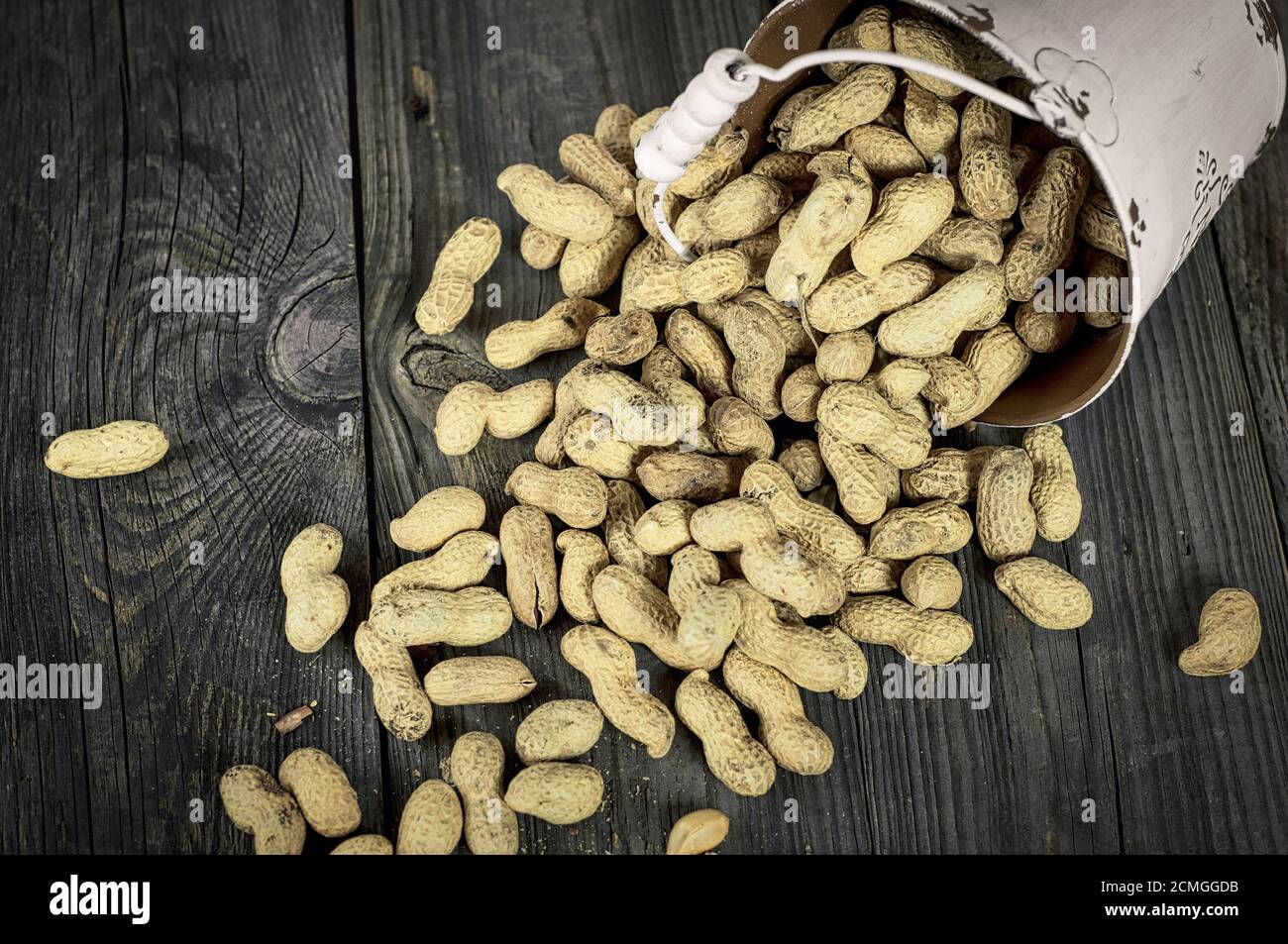 Loose peanuts in the shell on a gray wooden surface, vintage toning ...