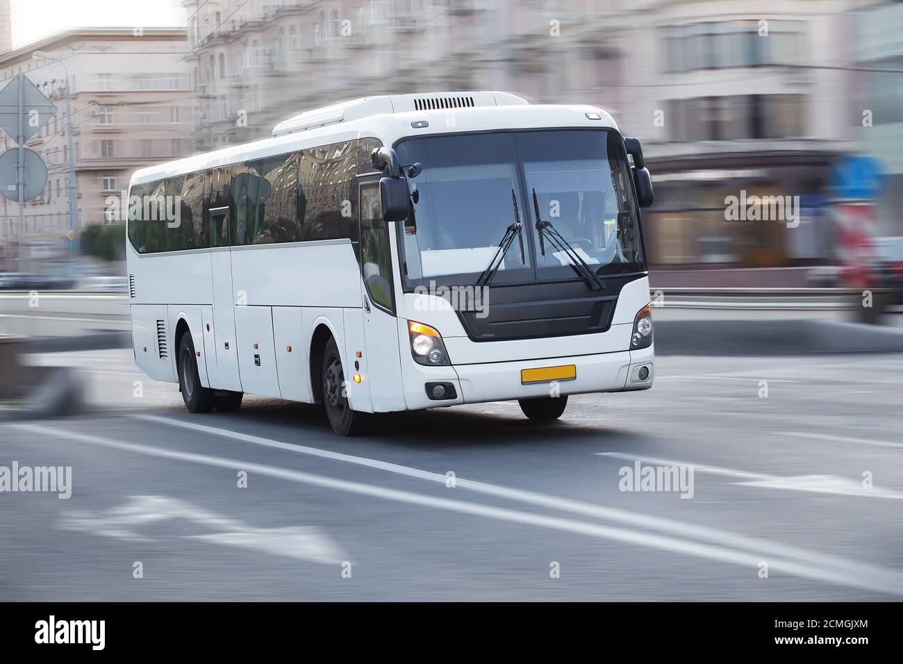 white city bus goes along street Stock Photo - Alamy