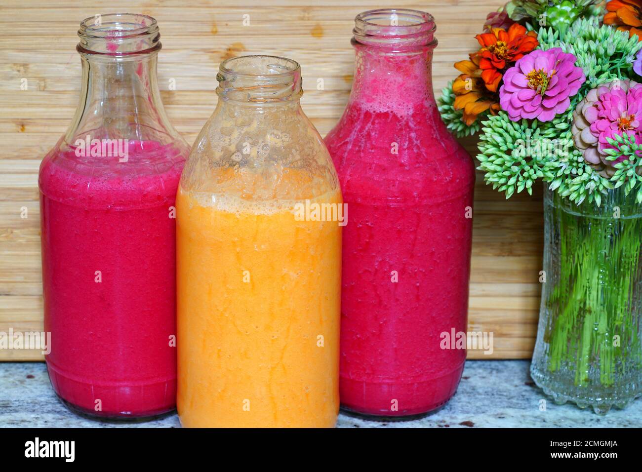 Glass bottles filled with colorful fresh homemade beet and peach ...