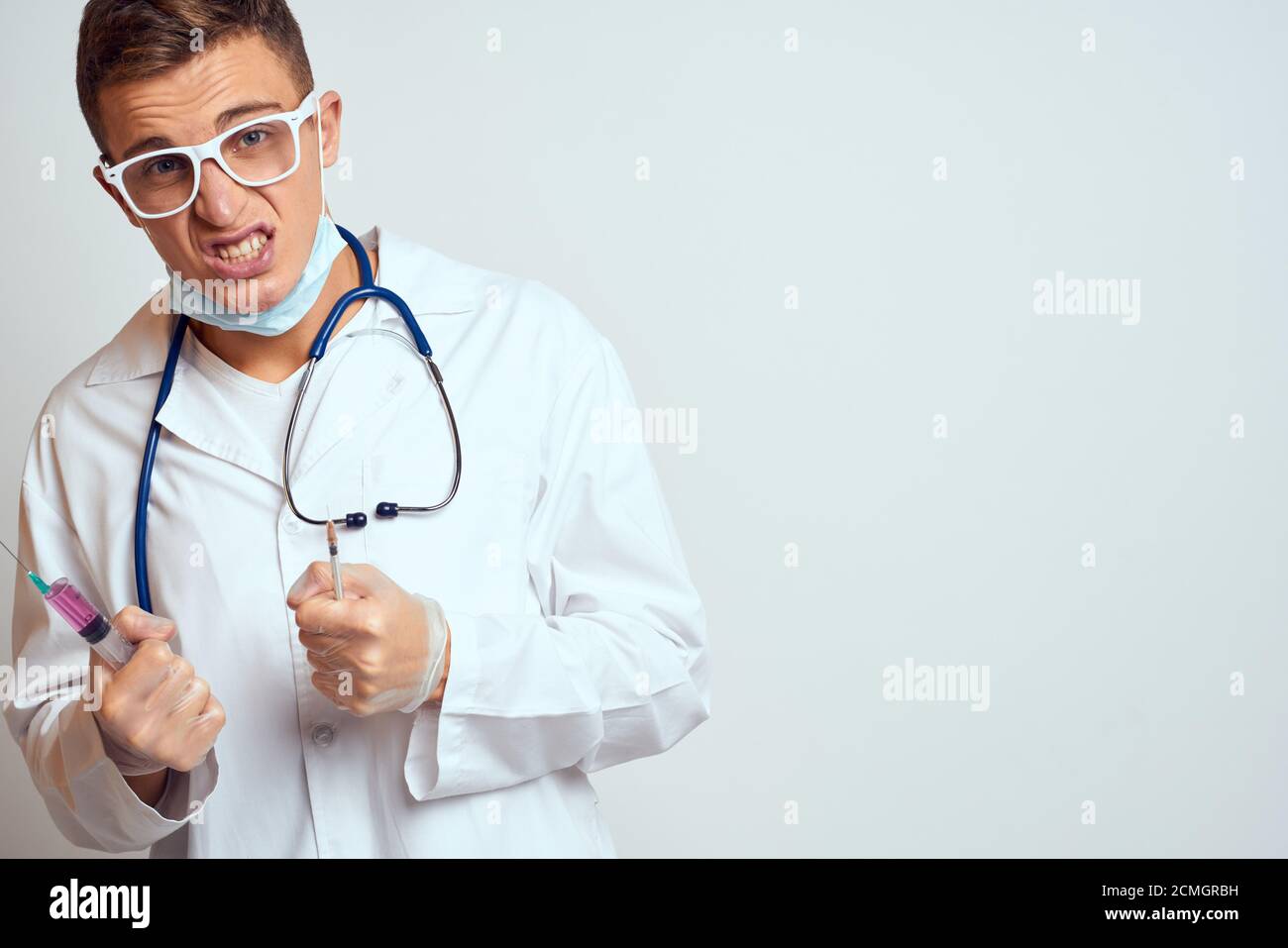 doctor in a medical gown with a stethoscope and glasses on a light ...