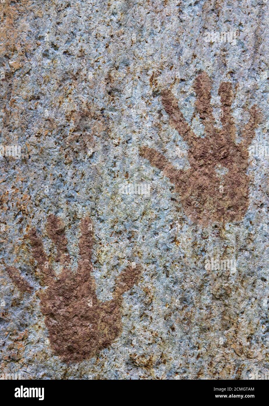 Human hand prints painted on stone surface Stock Photo - Alamy