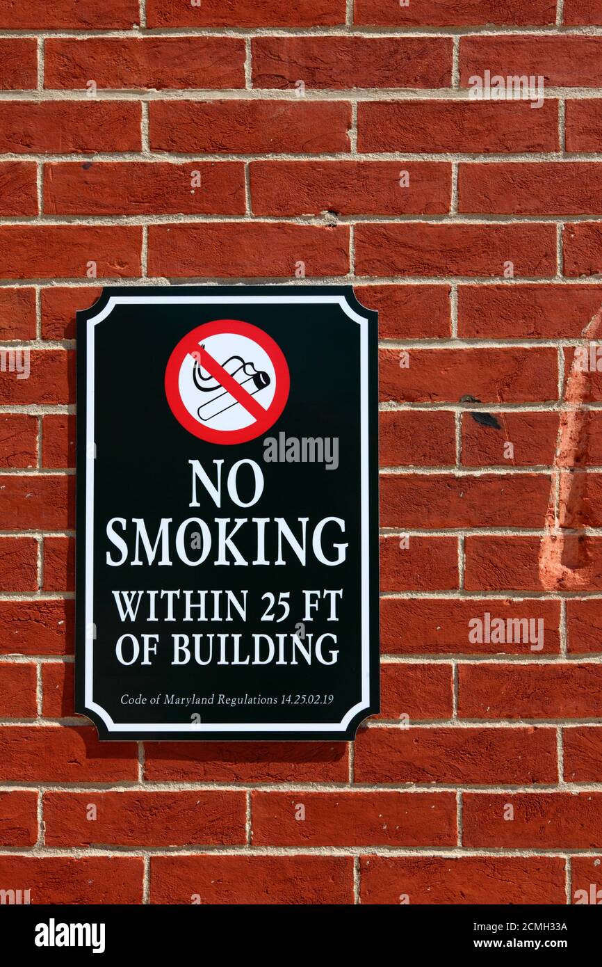 "No smoking within 25 feet of building" sign on brick wall outside ...
