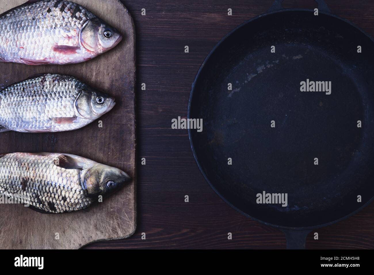 Three live carp fish in a scales on a kitchen board Stock Photo - Alamy