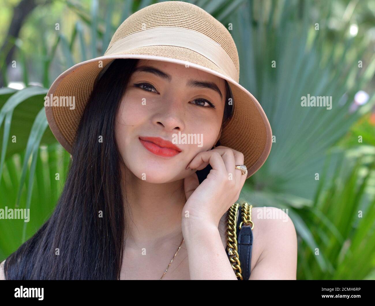 Beautiful Southeast Asian Woman Wears A Modern Sun Hat And Smiles For