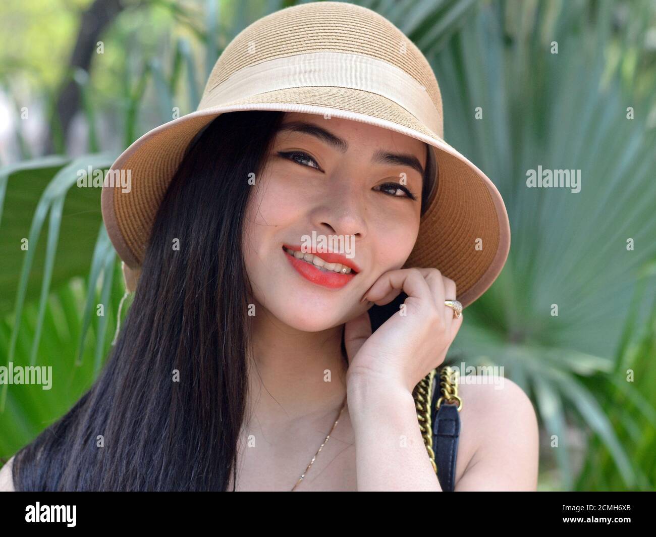 Beautiful Southeast Asian woman wears a modern sun hat and smiles for ...