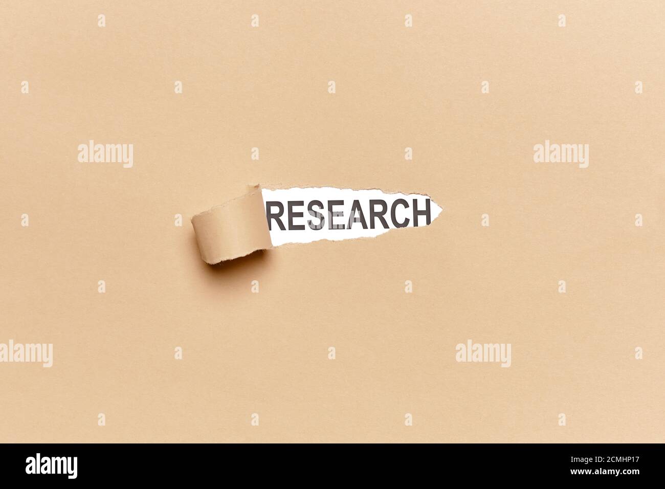 Brown torn paper with the word RESEARCH appearing. Medicine concept ...