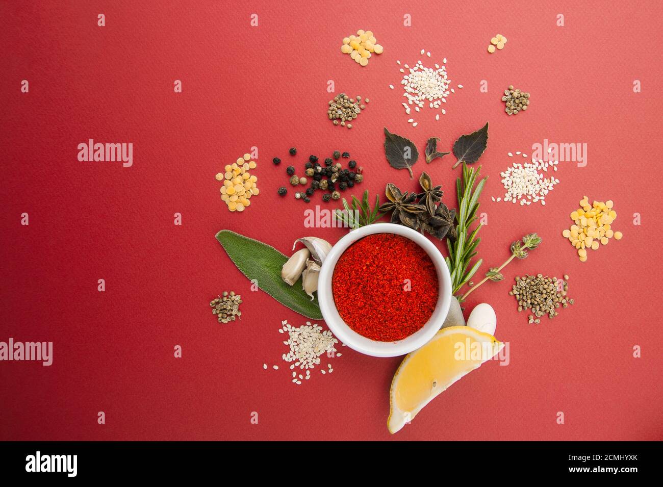 Dried chopped paprika, spicy herbs and various seasonings on a red ...