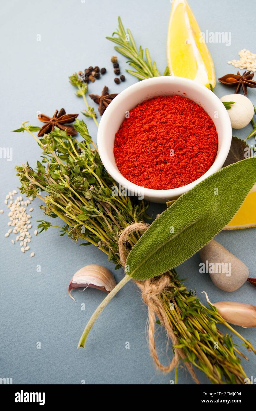 Dried chopped paprika and spicy herbs on a light blue pastel background ...
