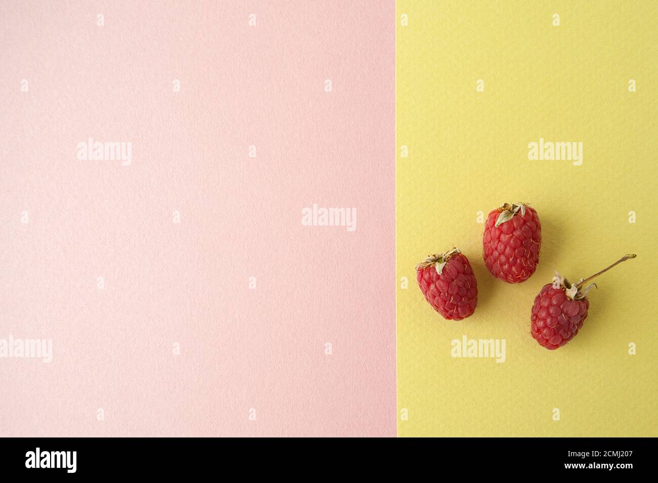 Three ripe raspberries on a pastel yellow-green background Stock Photo ...