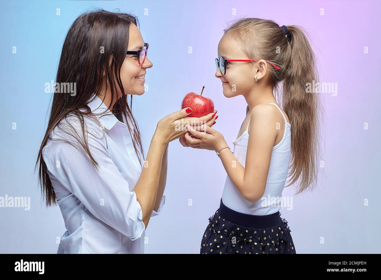 mother and daughter hold a large red Apple in their hands Stock Photo ...