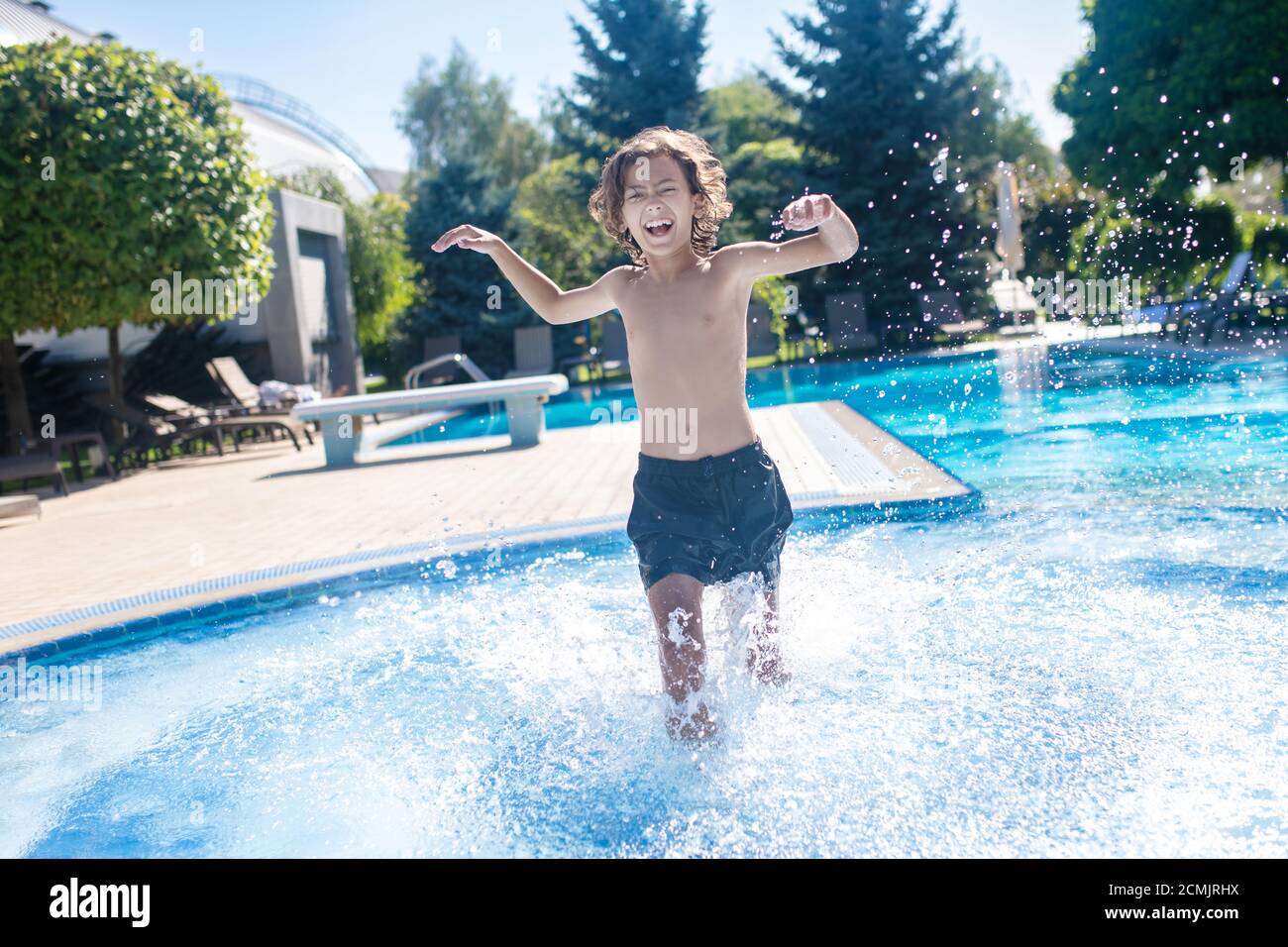Enthusiastic boy running in the outdoor pool Stock Photo - Alamy