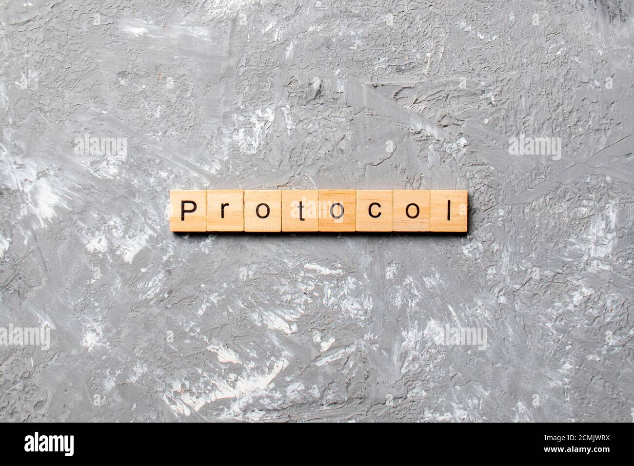 PROTOCOL word written on wood block. PROTOCOL text on cement table for ...