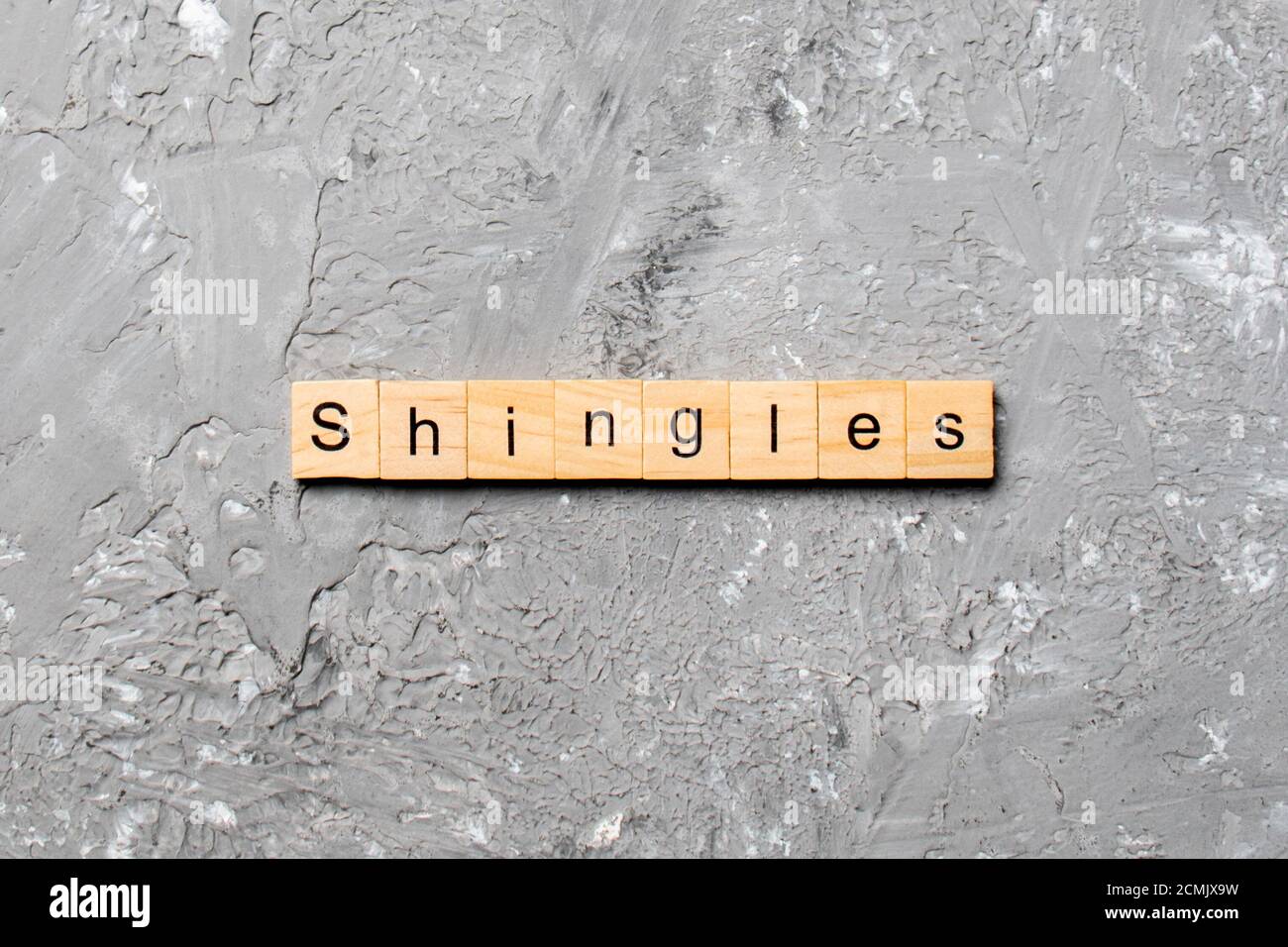 Shingles word written on wood block. Shingles text on cement table for ...