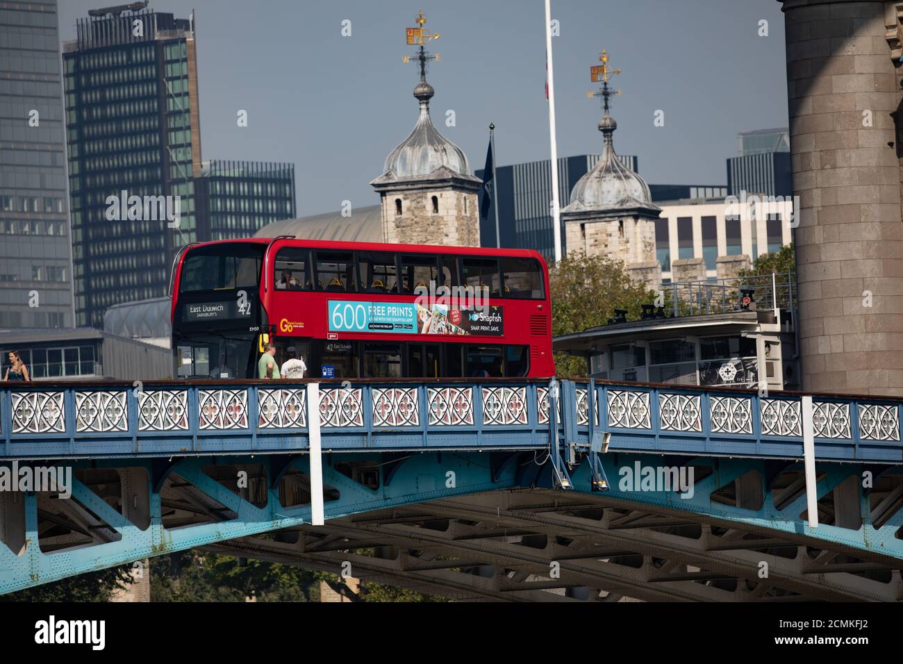 A red bus crossing Tower Bridge in London, UK Stock Photo - Alamy