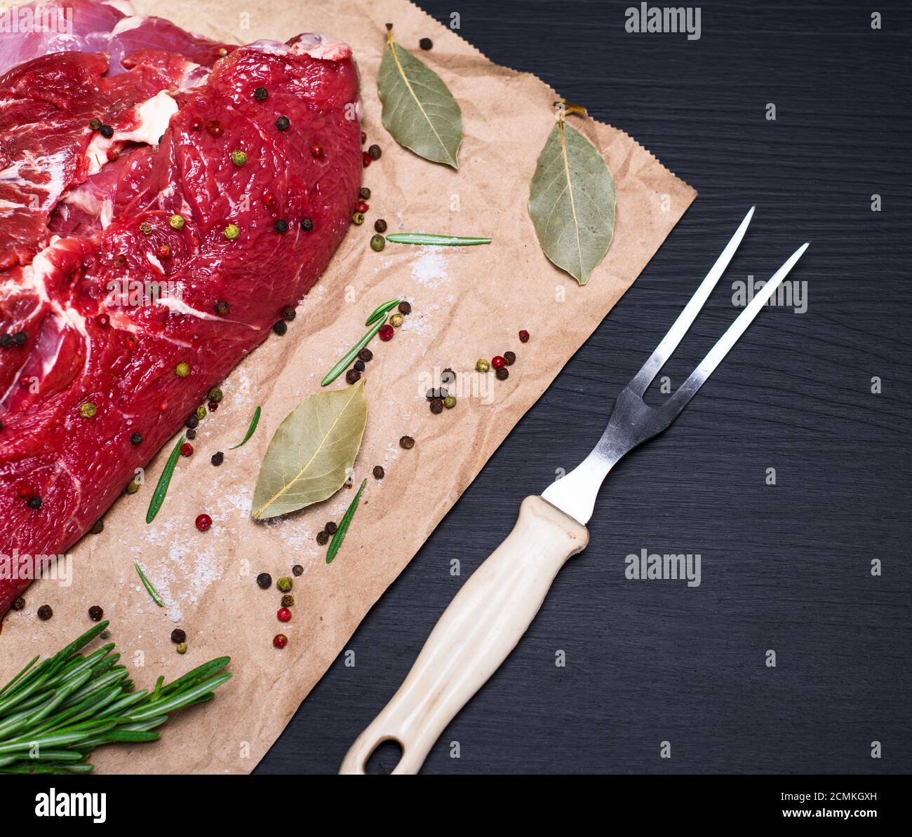 beef tenderloin on brown kraft paper and a kitchen fork Stock Photo - Alamy