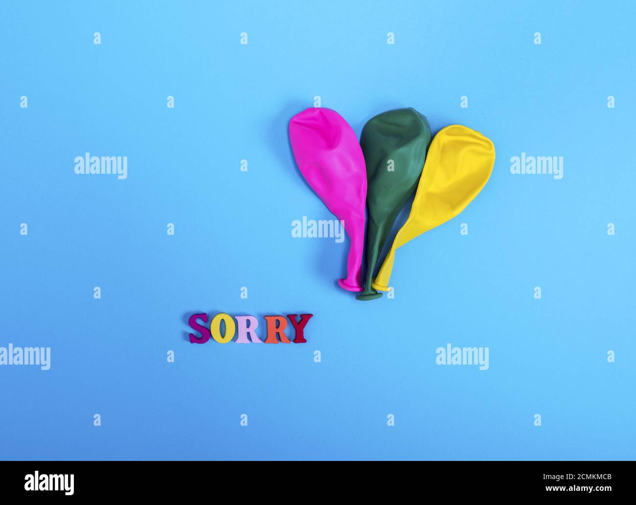 three blow off balloons and the word sorry Stock Photo - Alamy