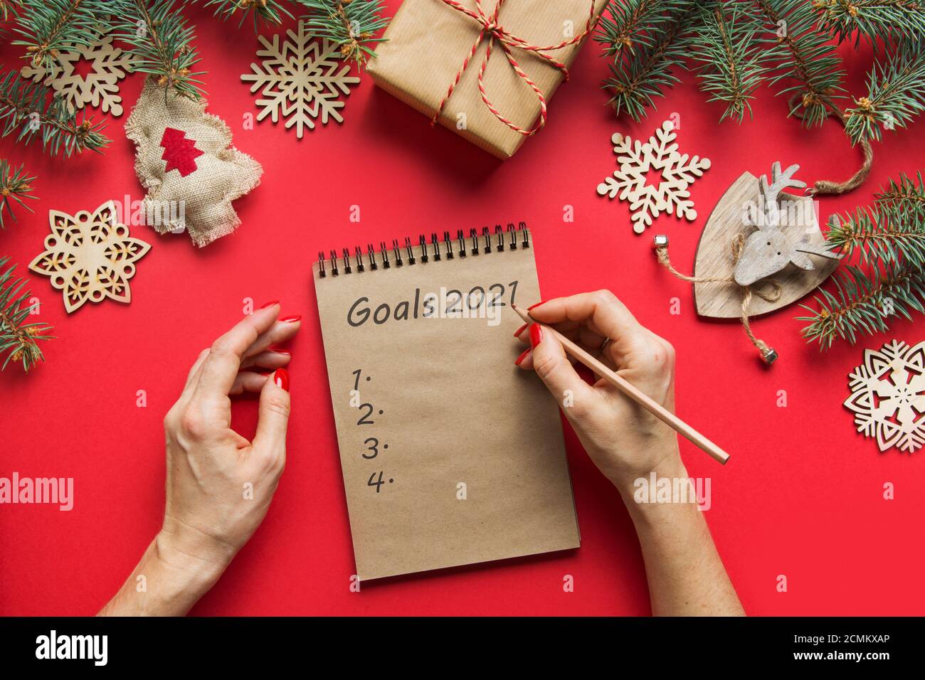 Woman writing New Year goals and planning in craft notebook. View from ...