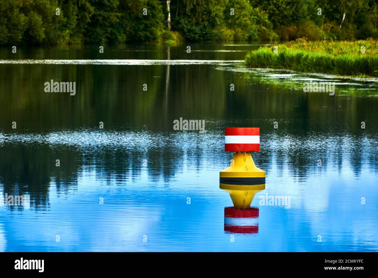 Yellow red buoy on a calm river to mark the shipping route in the upper ...