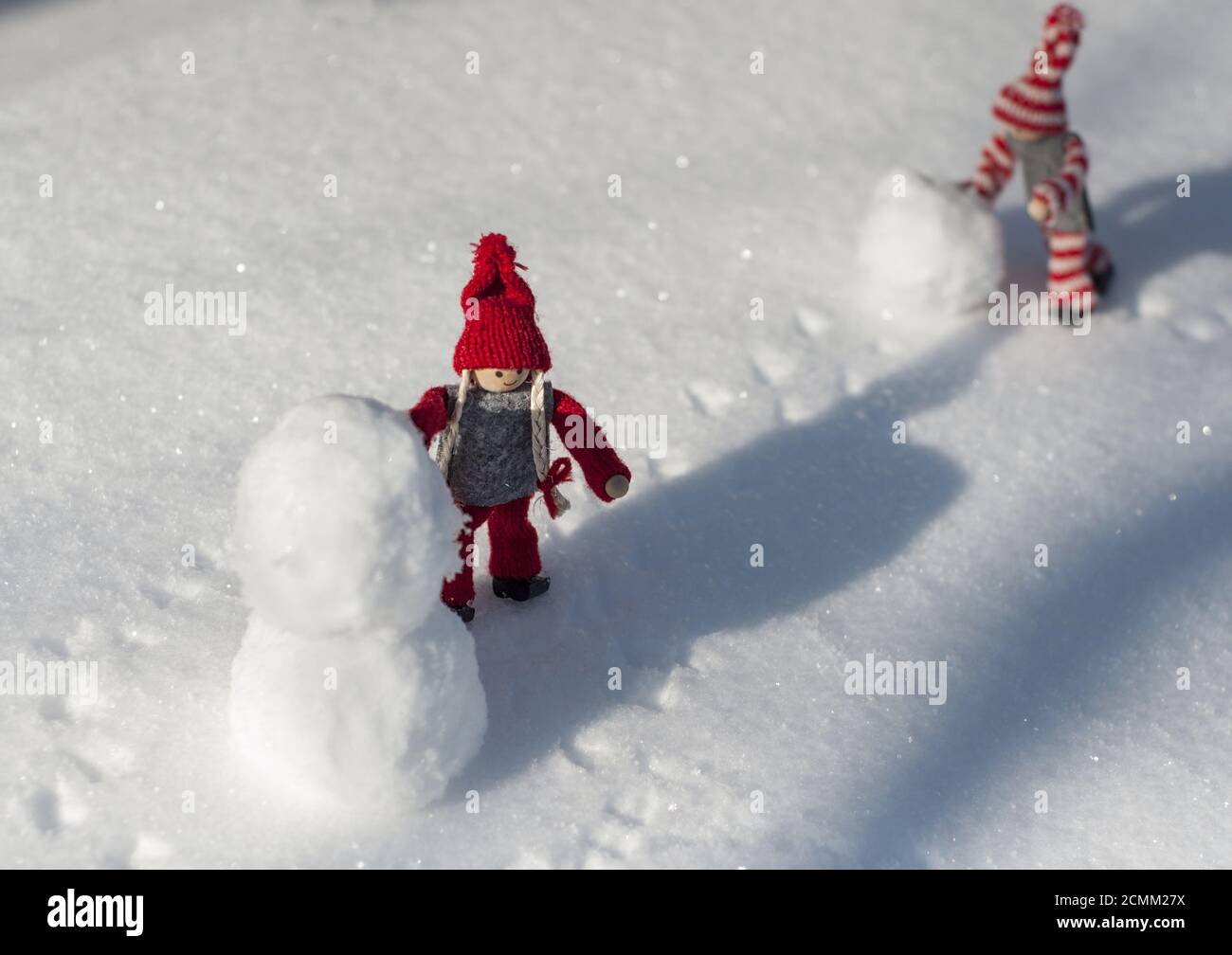 Two toy little men playing in the snow Stock Photo - Alamy