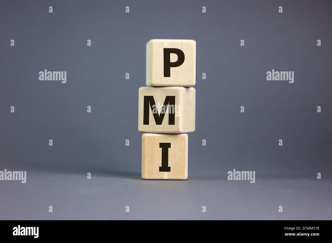 Wood cubes with word 'PMI' stacking as stack on beautiful grey ...