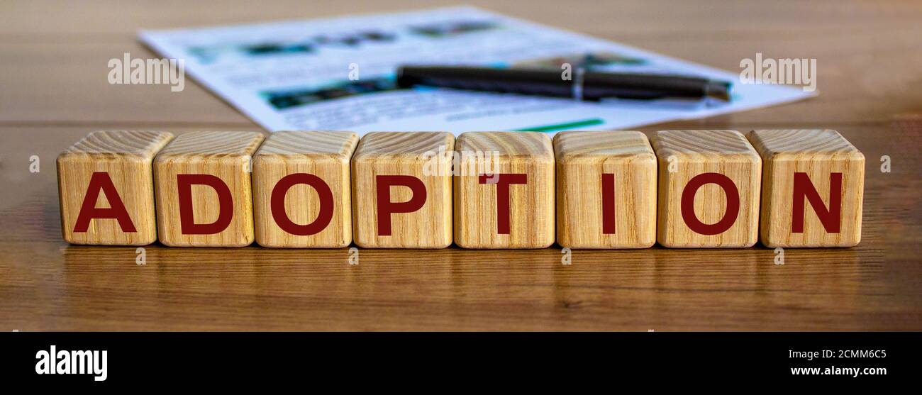Concept word 'adoption' on cubes on a beautiful wooden table, pen and ...