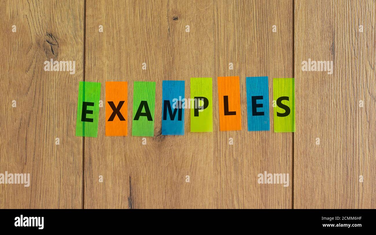 Colored papers with word 'examples' on beautiful wooden background ...