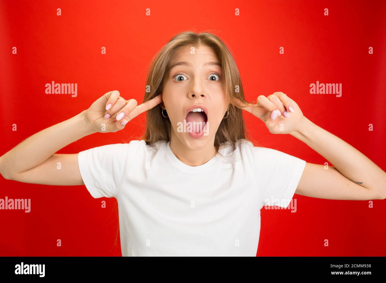 Closing ears. Portrait of young caucasian woman with bright emotions on ...