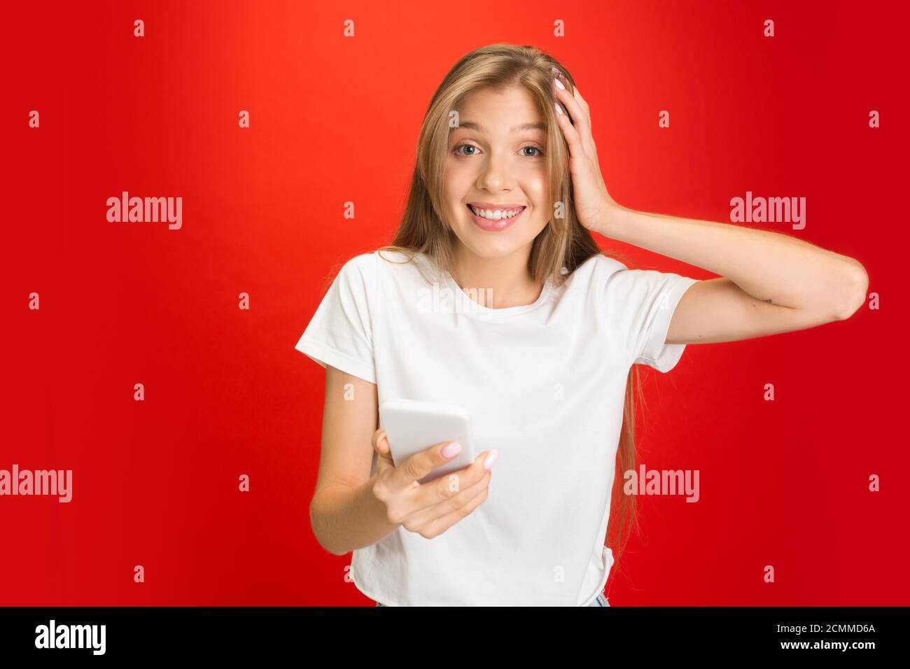 Shocked scrolling phone. Portrait of young caucasian woman with ...