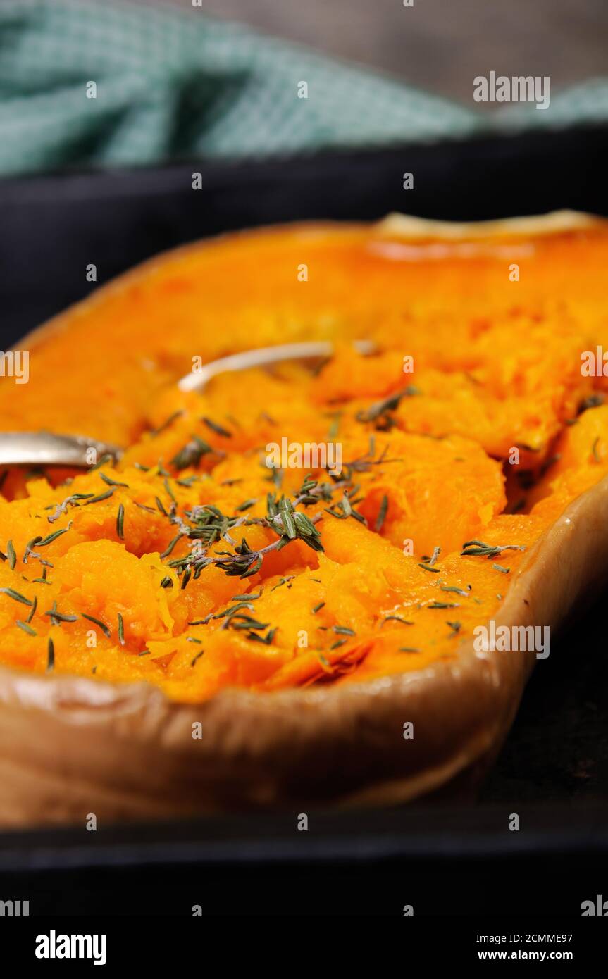Baked pumpkin with a tender, juicy pulp flavored with thyme. Close-up ...