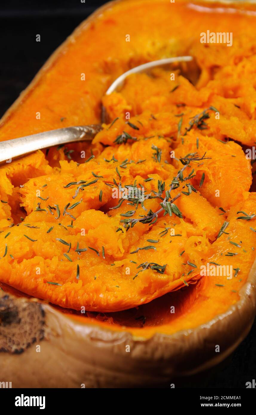 Baked pumpkin with a tender, juicy pulp flavored with thyme. Close-up ...